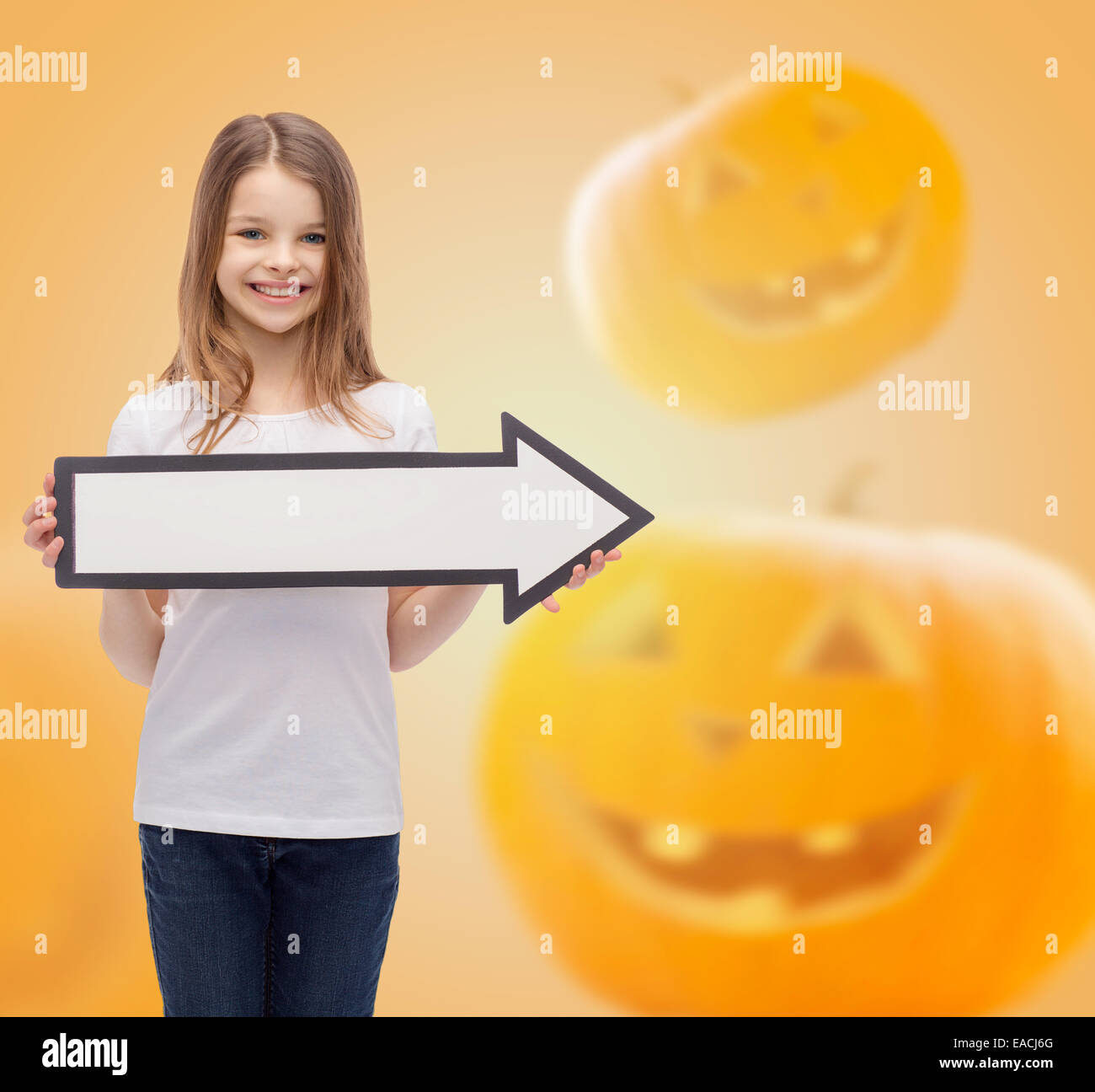 smiling little girl holding big white arrow Stock Photo - Alamy