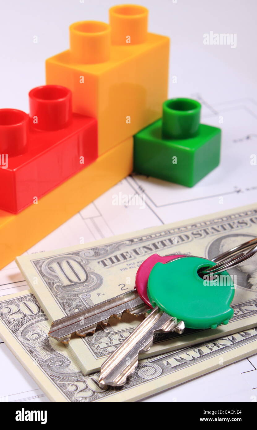 Heap of banknotes, home keys and wall of plastic colorful building ...