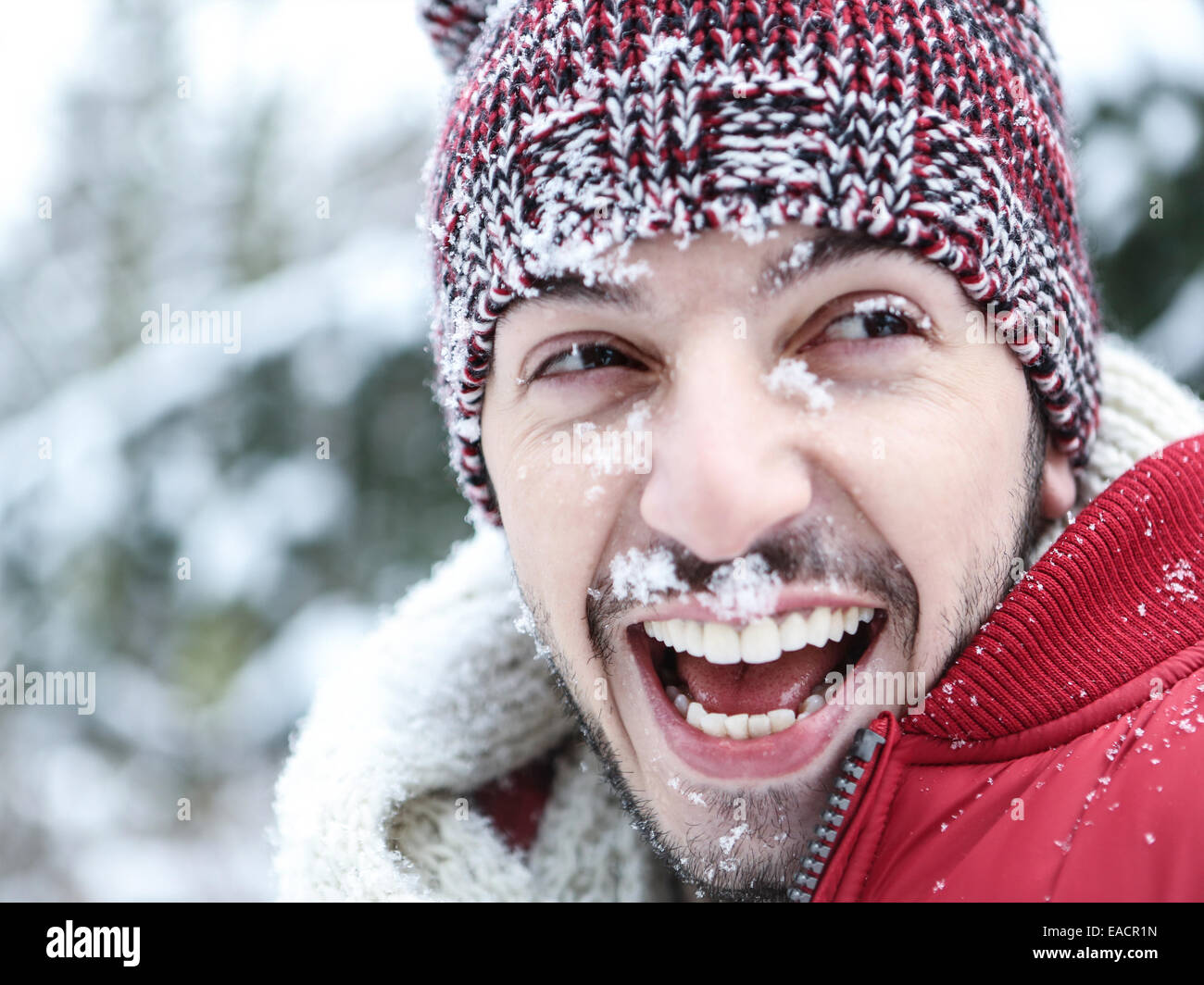 Happy smiling man with snow in his face in winter Stock Photo - Alamy