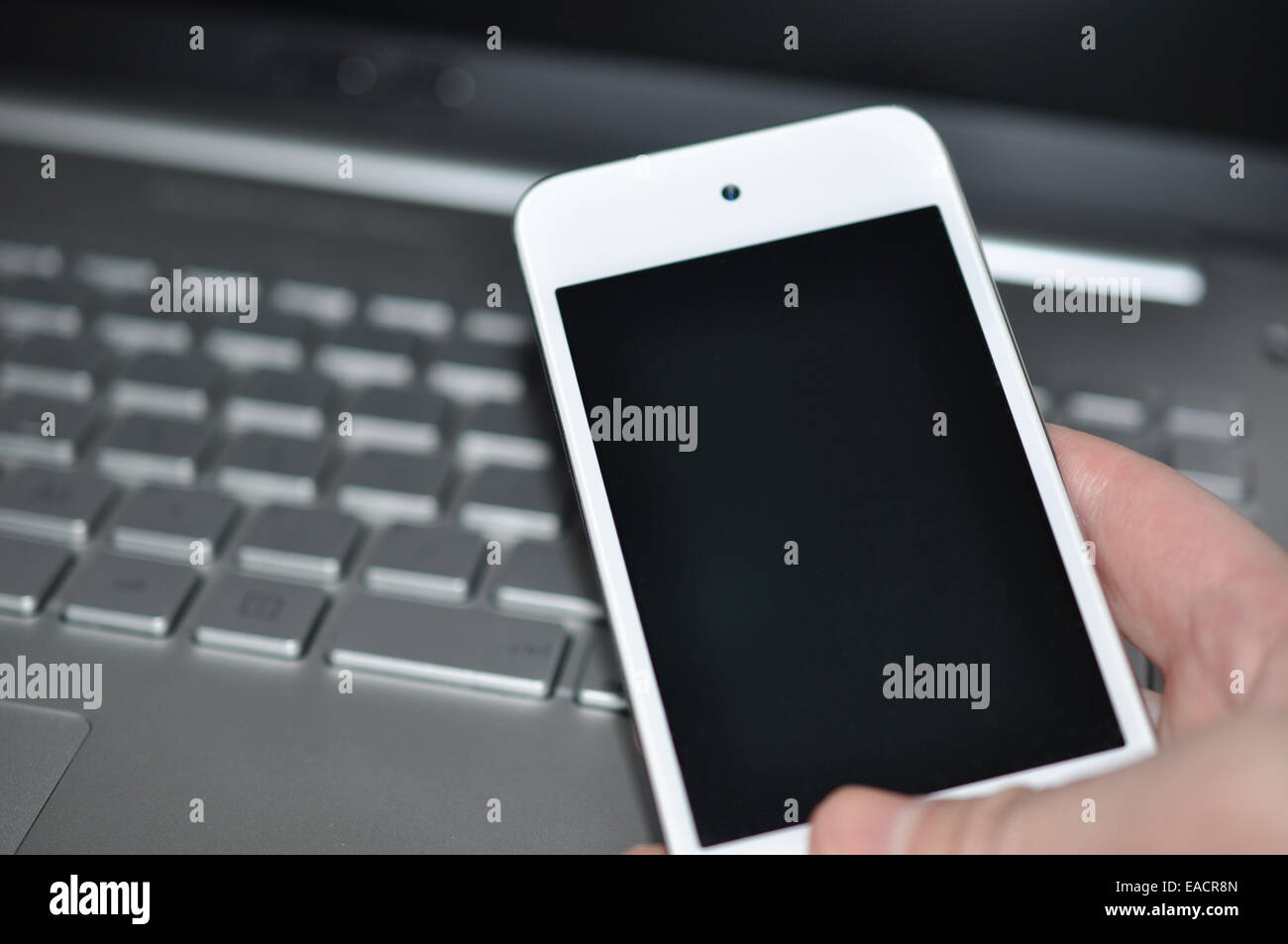 Hand holding smartphone with computer keyboard background Stock Photo ...