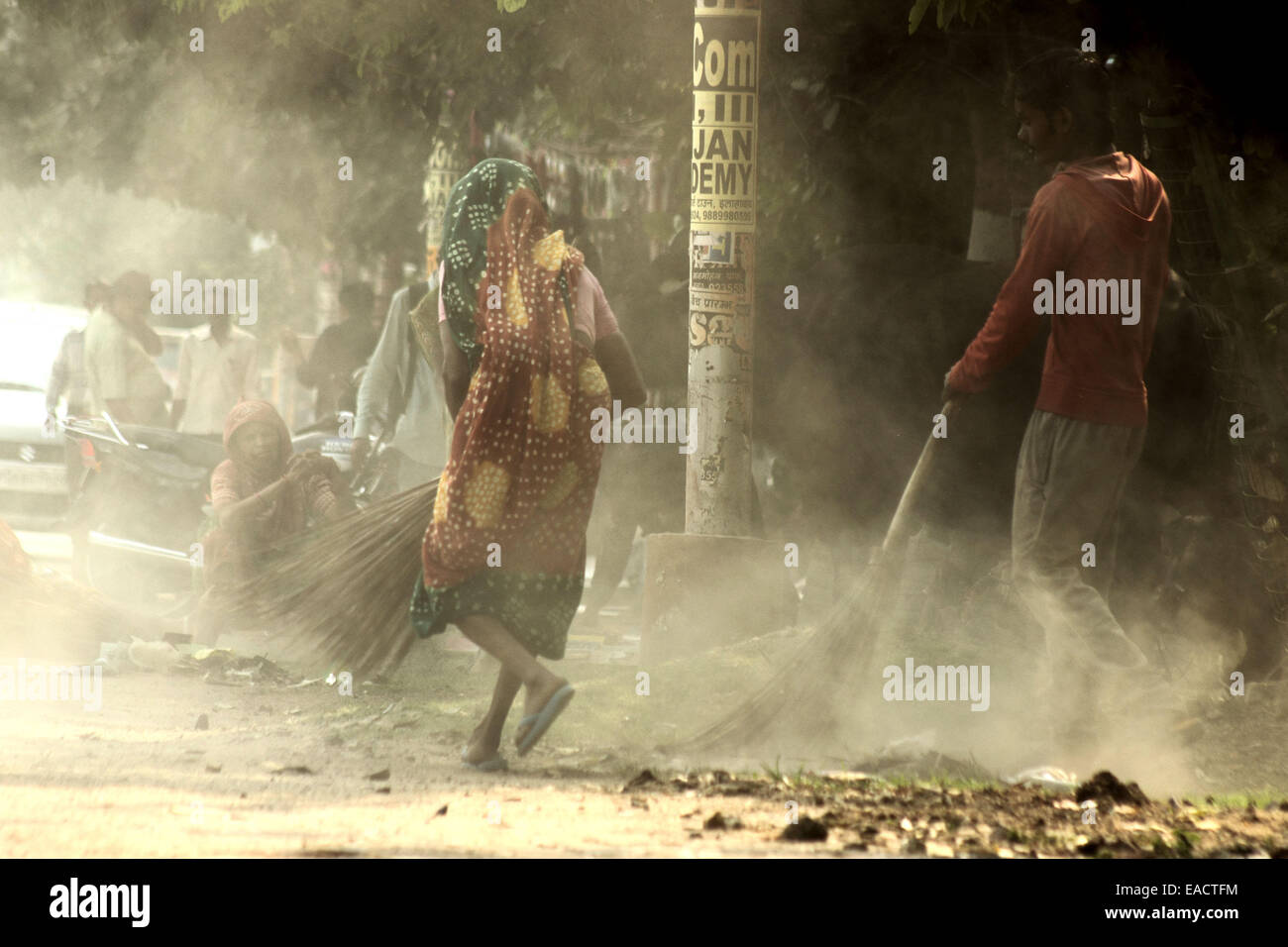 Sweepers (Safai Karmchari) surrounded by dust cleaning the streets of ...