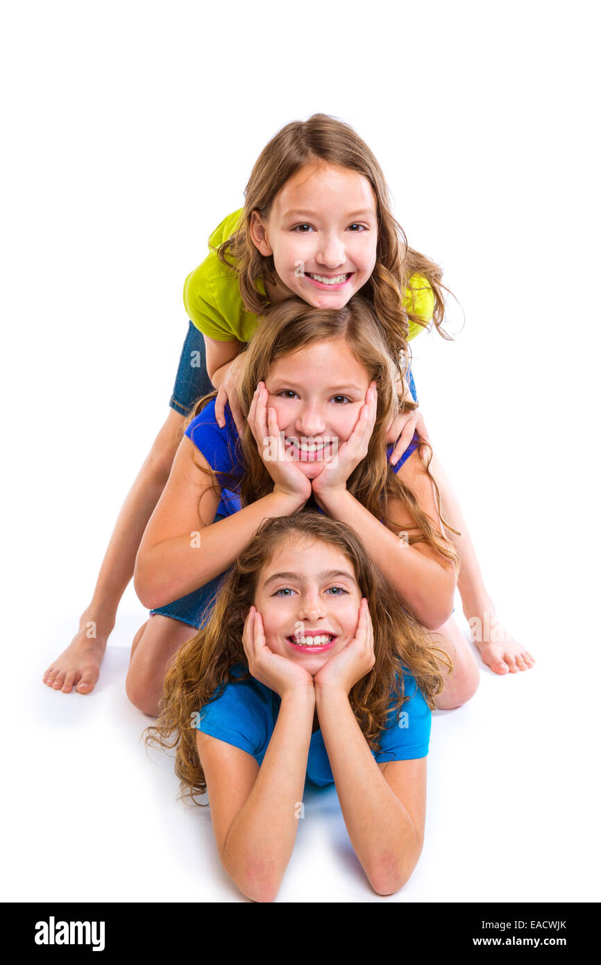 Three kid girls friends happy stacked in a row portrait on white ...