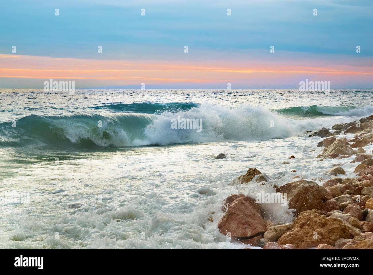 Sea landscape with waves on the beach against sunset Stock Photo - Alamy