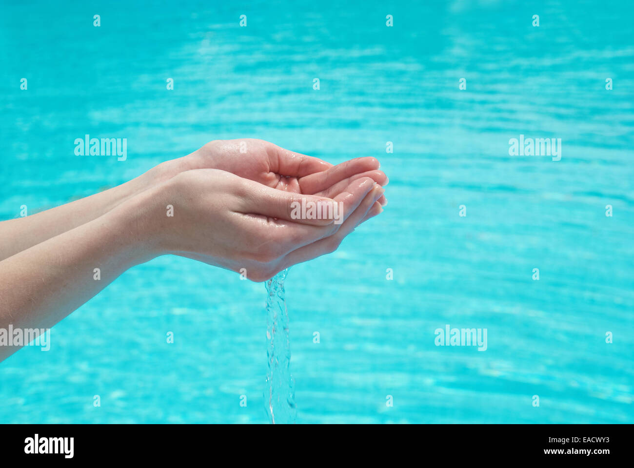 Human hands with clear water on the blue background Stock Photo - Alamy