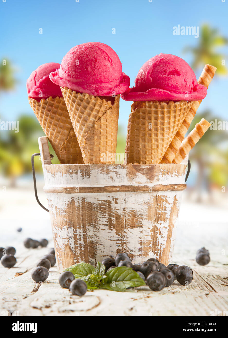 Fruit ice cream with blur beach as background. Served on wooden planks ...
