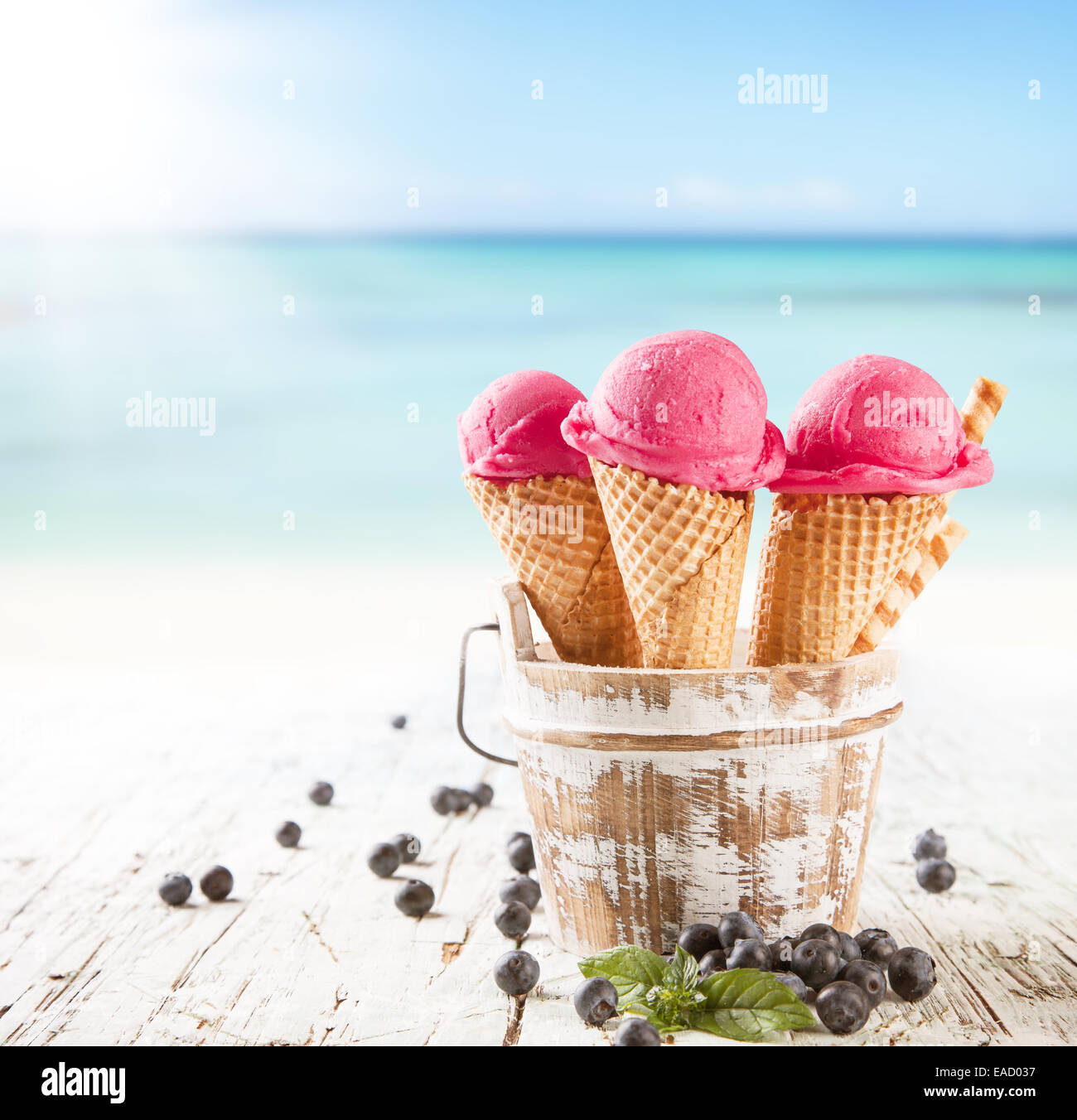 Fruit ice cream with blur beach as background. Served on wooden planks ...