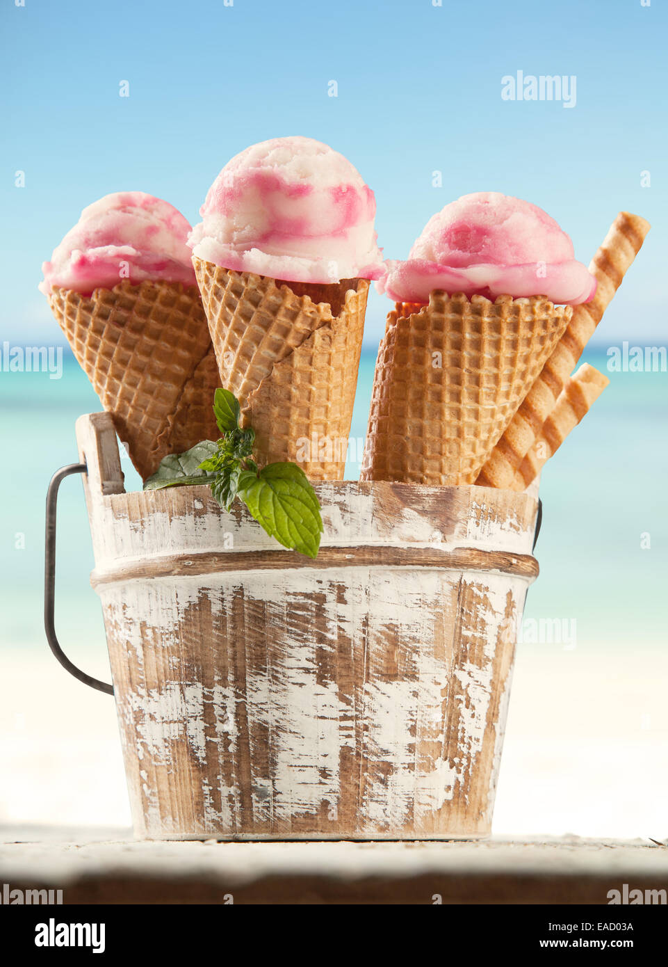 Fruit ice cream with blur beach as background. Served on wooden planks ...