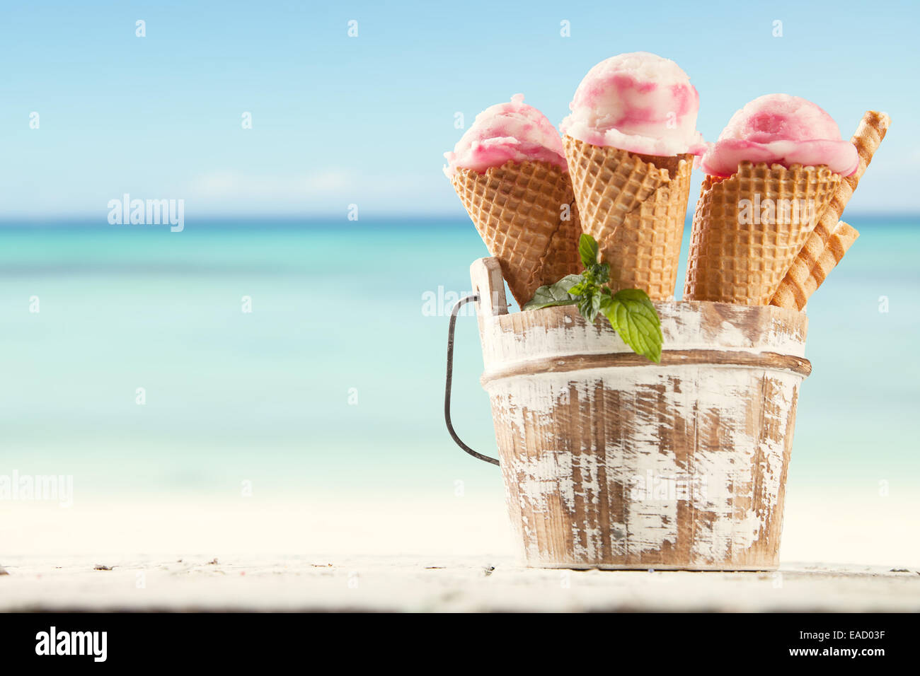 Fruit ice cream with blur beach as background. Served on wooden planks ...