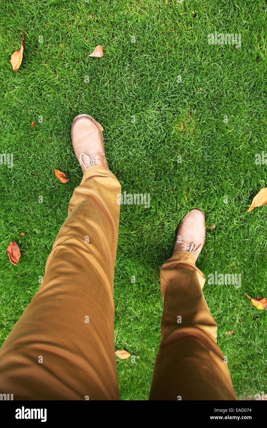 Walking in the park. Man's feet in shoes on the grass. Top view Stock ...