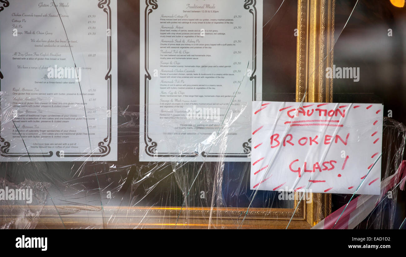 'Caution Broken Glass' sign on cracked windows shop fronts with hand ...