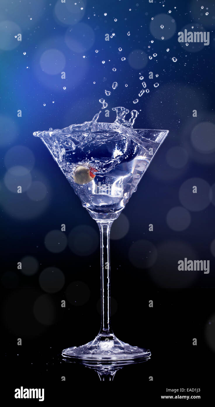 Martini drink splashing out of glass Stock Photo - Alamy