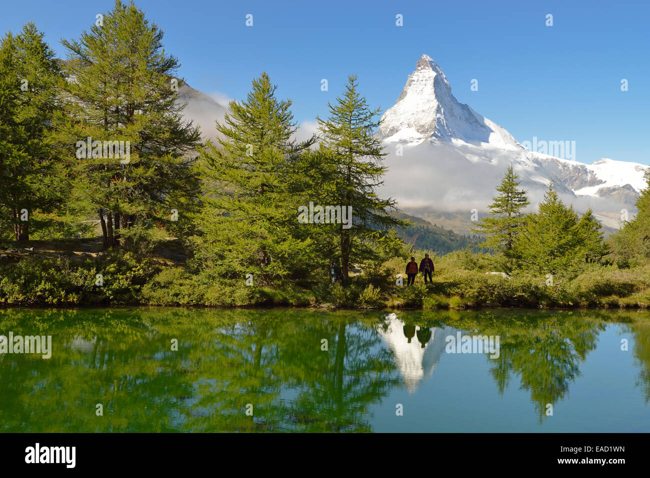 Hiker standing at Lake Grindjisee, with the Matterhorn at the rear ...