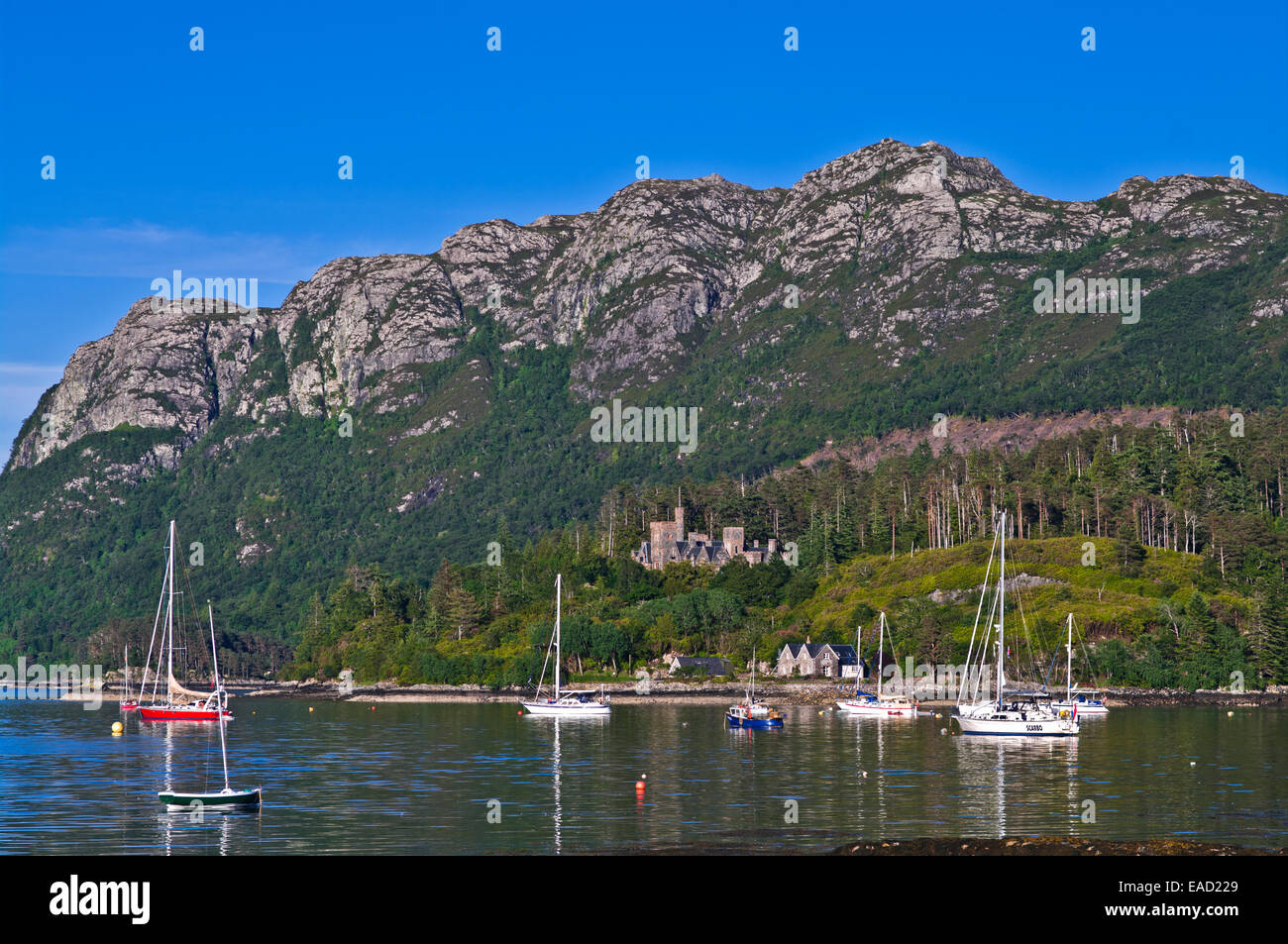 View across yachts anchored in Plockton harbour to Duncraig Castle ...