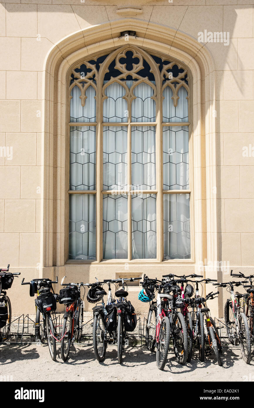 Bicycles stand in a row under the big historic window Stock Photo - Alamy