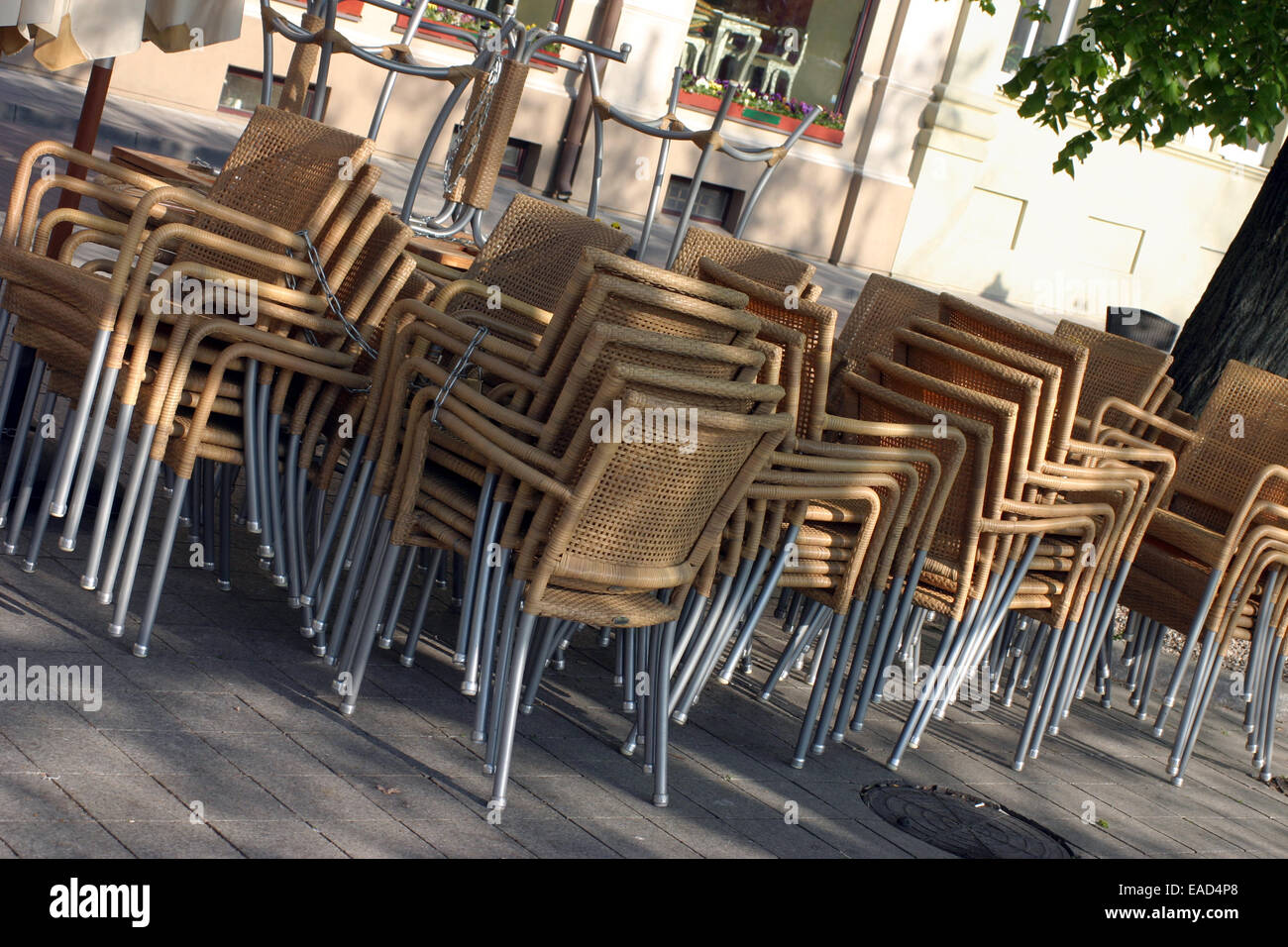 Stacked and chained cafe chairs early in the morning Stock Photo - Alamy