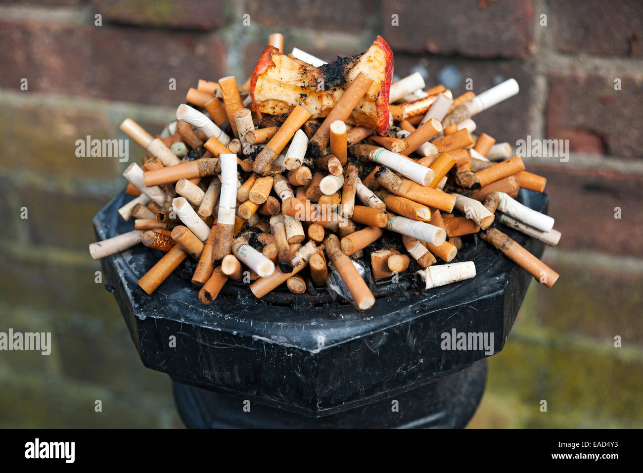 Close up of pile of cigarette cigarettes butts ends used in an ashtray ...