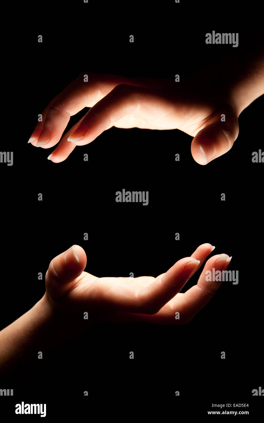 Hands almost touching eachother in the dark Stock Photo - Alamy