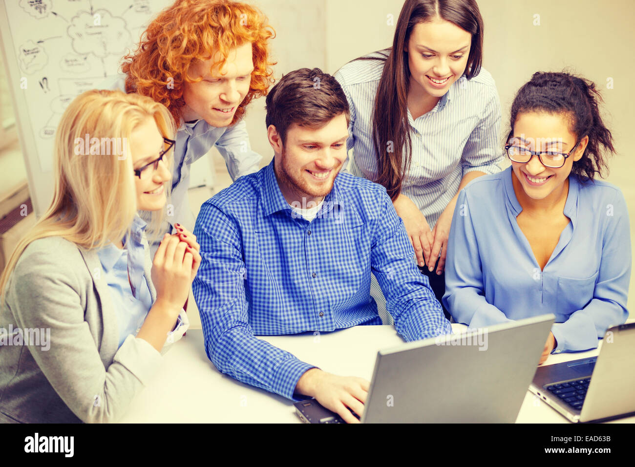 smiling team with laptop computers in office Stock Photo - Alamy