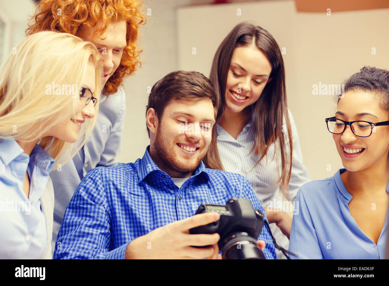 smiling team with photocamera in office Stock Photo - Alamy