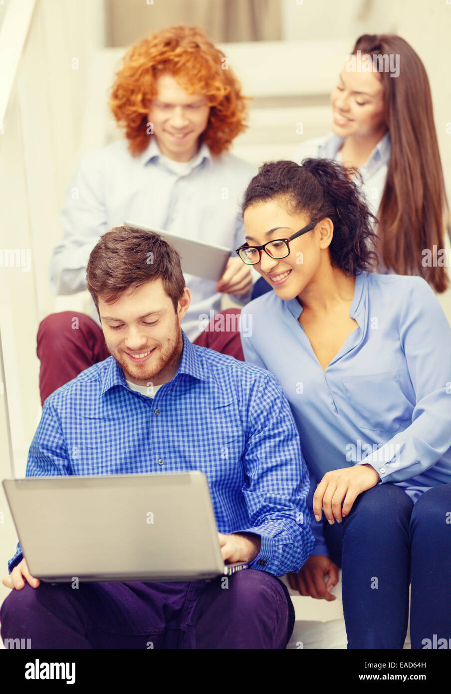 team with laptop and tablet pc on staircase Stock Photo - Alamy