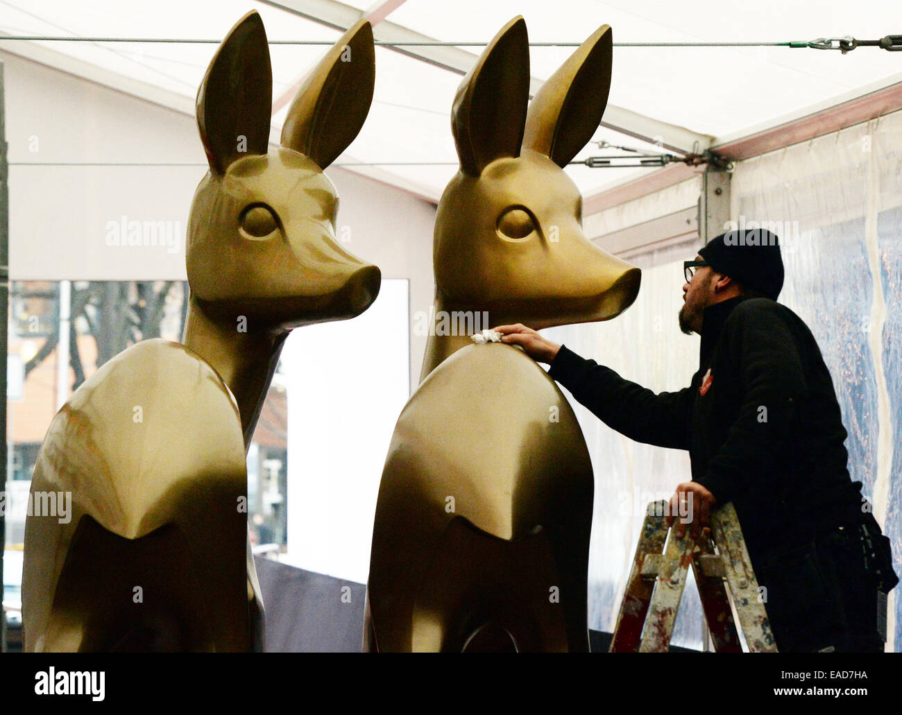 Berlin, Germany. 12th Nov, 2014. A worker polishes two giant 'Bambi ...