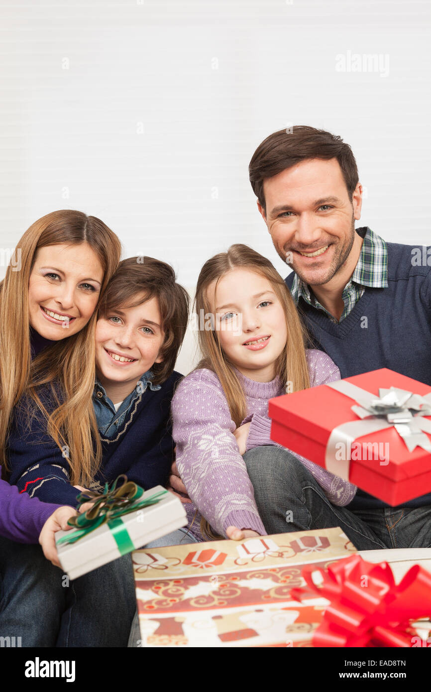 Family smiling giving presents Stock Photo - Alamy
