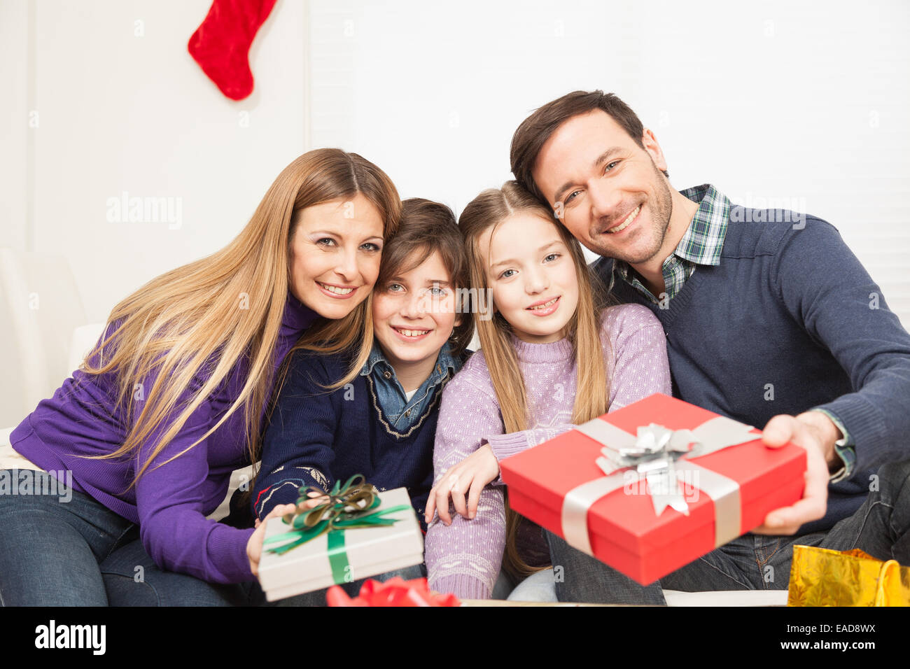 Family sitting together smiling hi-res stock photography and images - Alamy