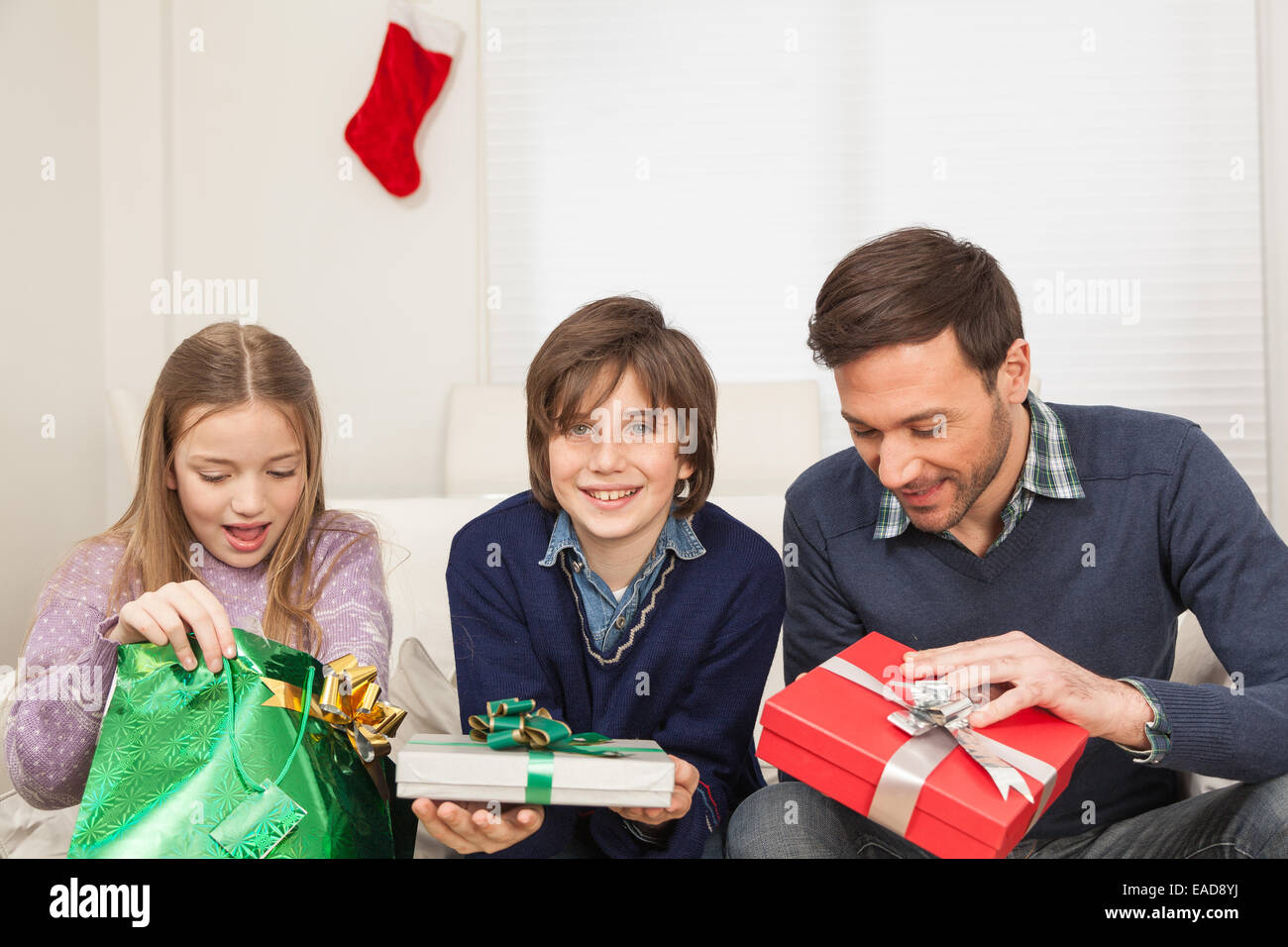 Father with his sons open his present for christmas Stock Photo - Alamy