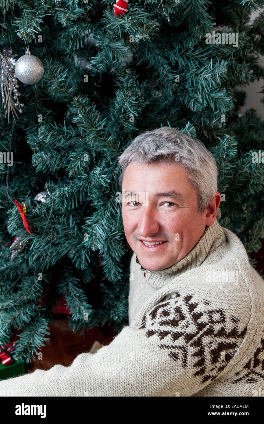 Man beside the christmas tree Stock Photo - Alamy