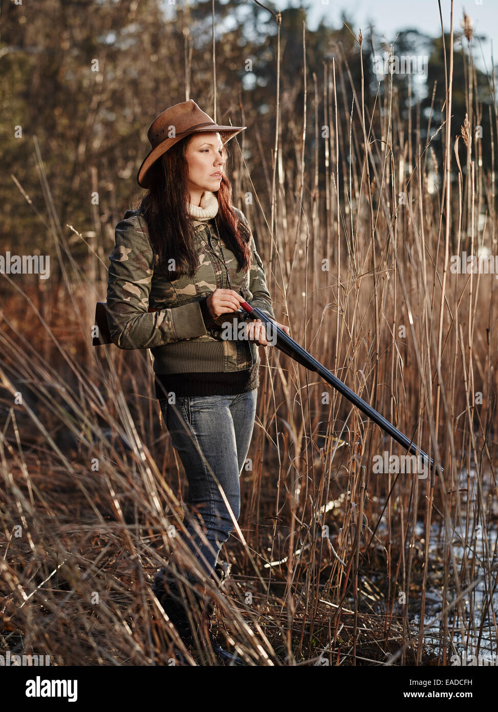 Waterfowl hunting, the female hunter loading the side by side shotgun ...