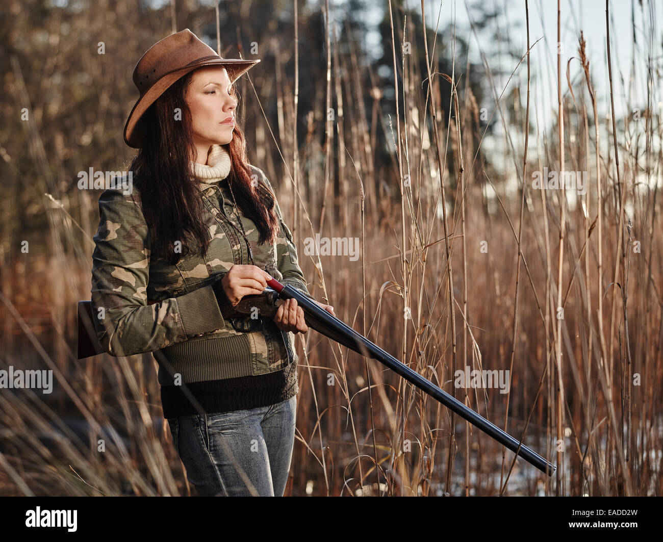 Waterfowl hunting, the female hunter loading the side by side shotgun ...