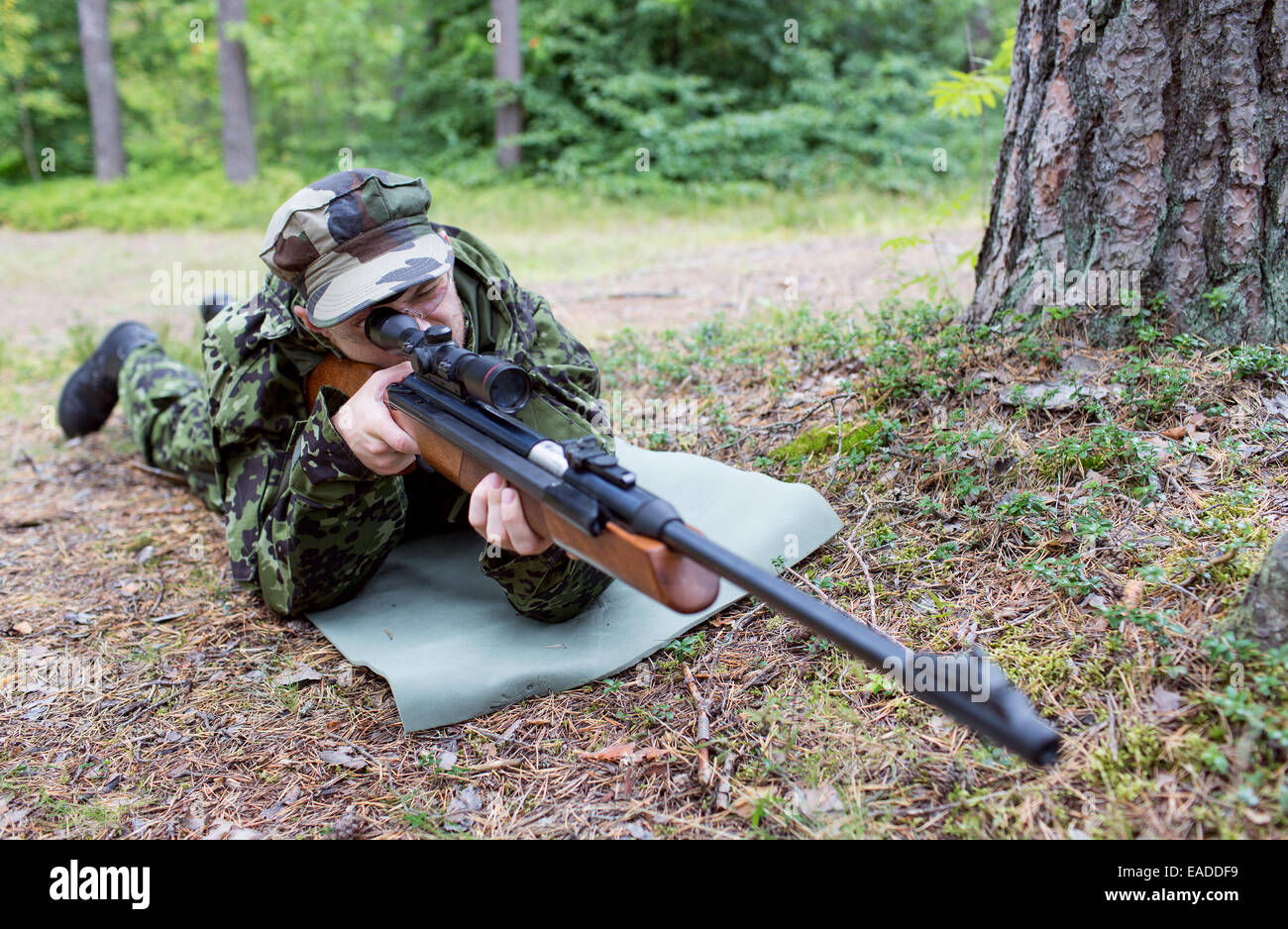 young soldier or hunter with gun in forest Stock Photo - Alamy