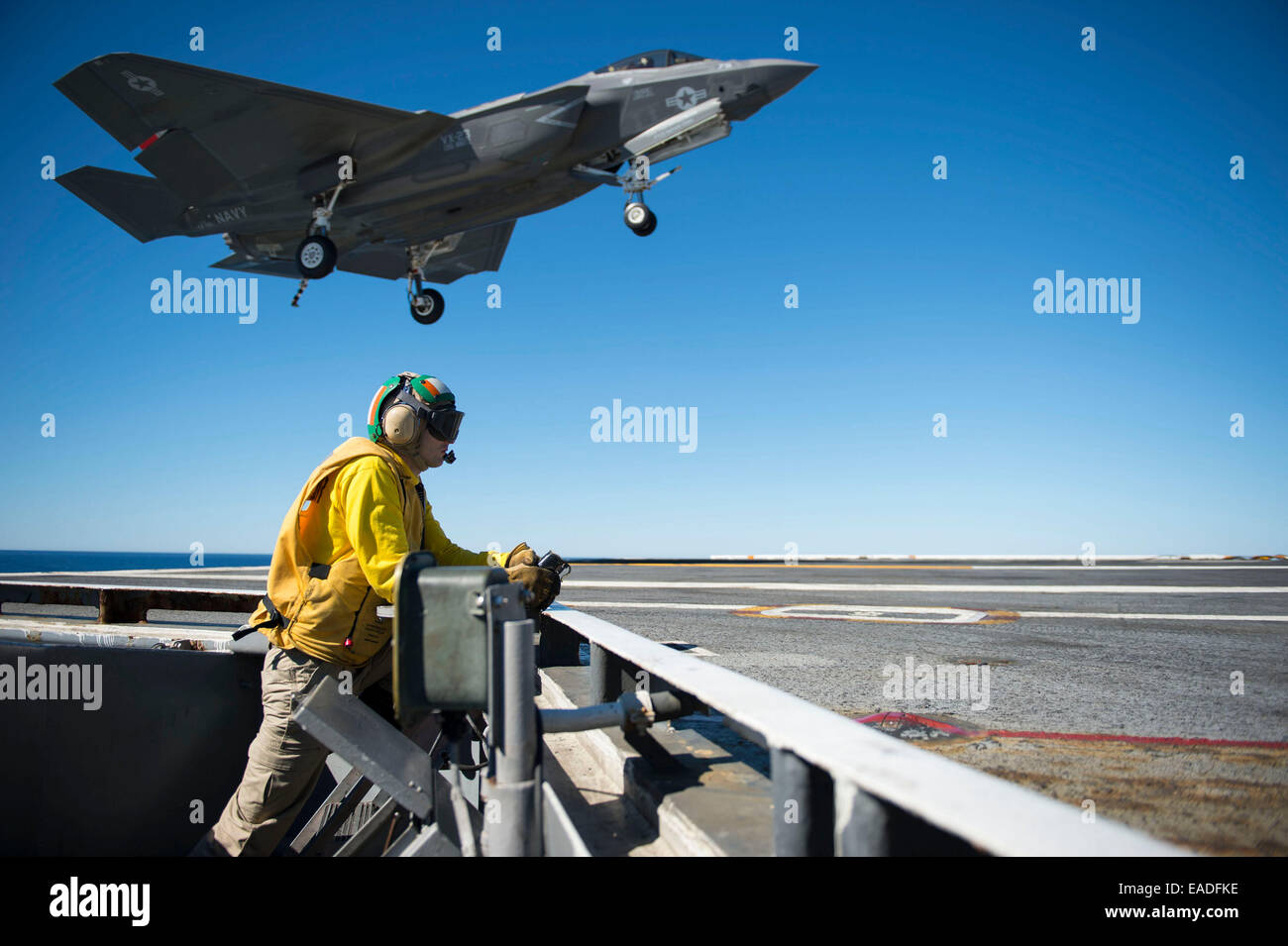 A US Navy flight crew watches a F-35C Lightning II joint strike fighter ...