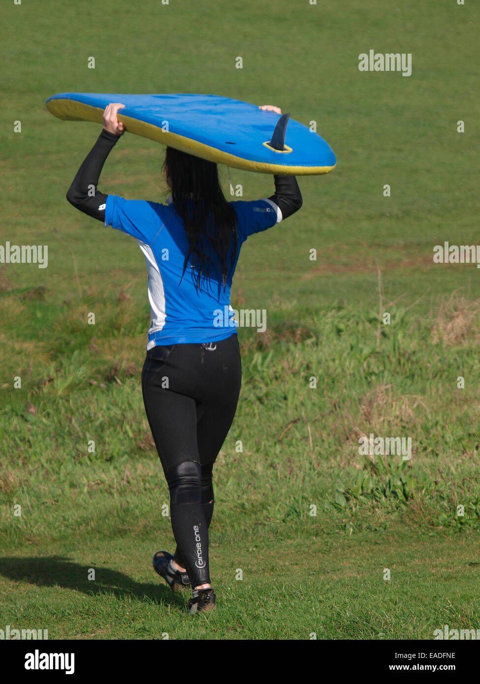Young woman carrying a surfboard on her head, Bude, Cornwall, UK Stock ...