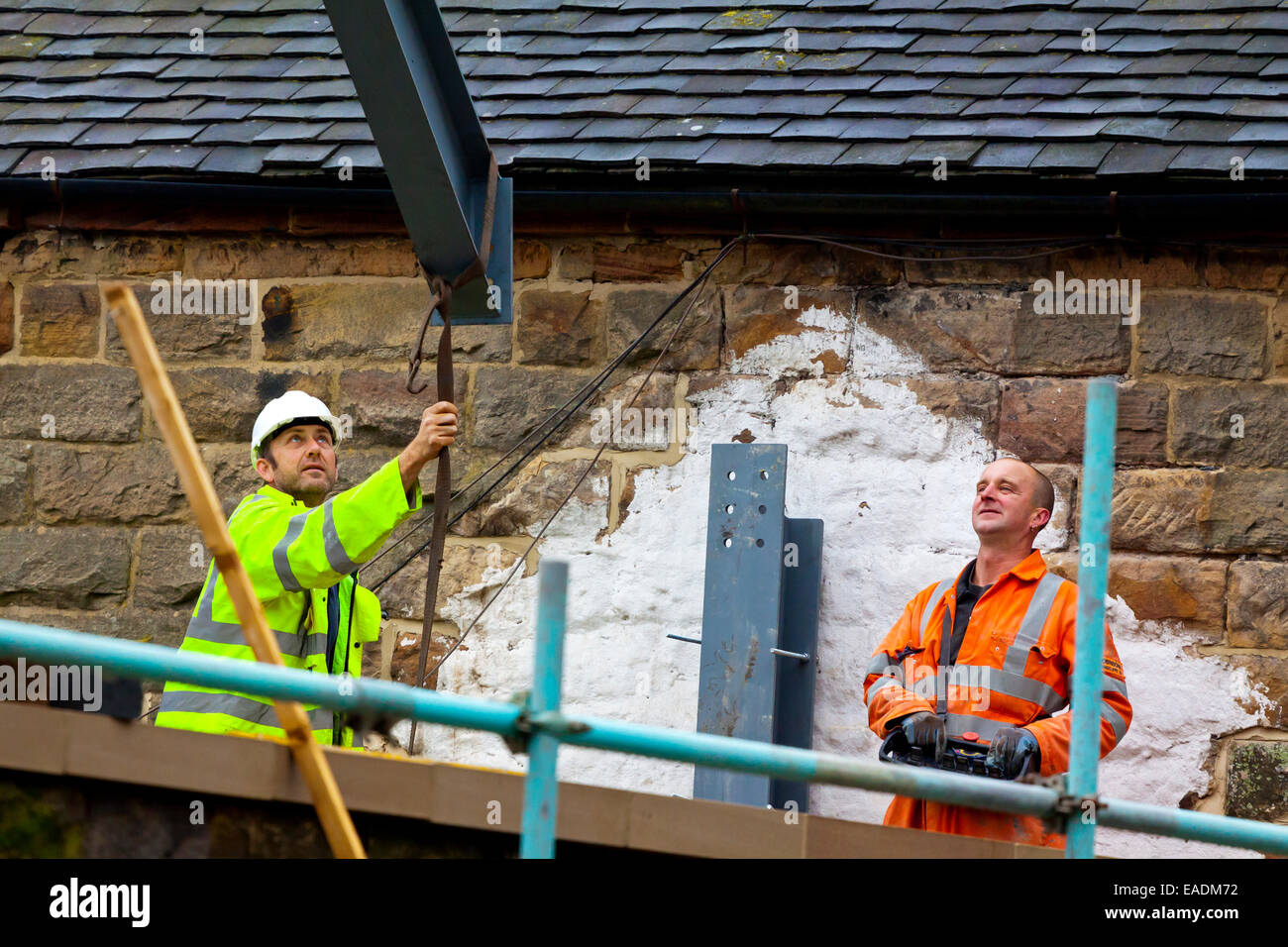 Builder and crane operator working on a construction site wearing a ...