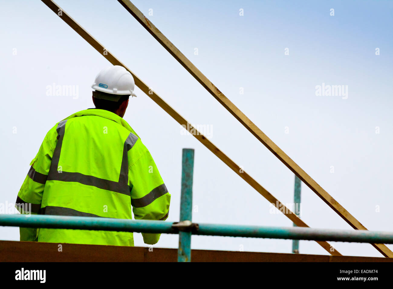 Builder working on scaffolding on a construction site wearing a high ...