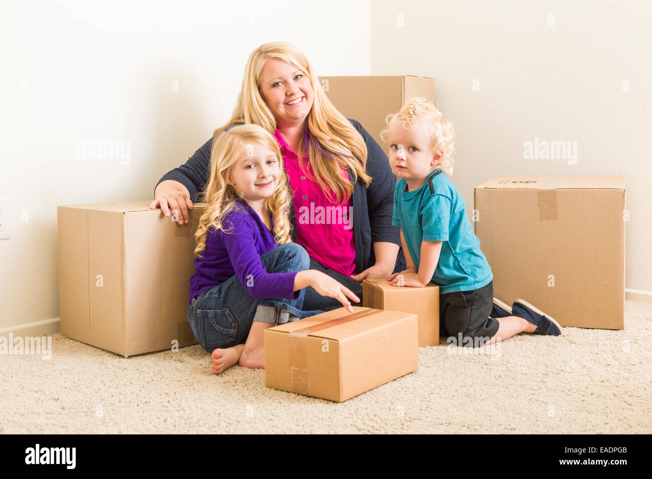 Happy Young Family in Empty Room With Moving Boxes Stock Photo - Alamy