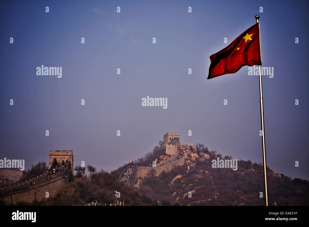 The Great Wall of China rises at sunset above the surrounding landscape ...
