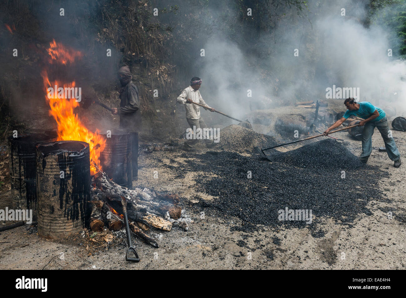 Workers applying hot asphalt to a road at a construction site, Shimla ...