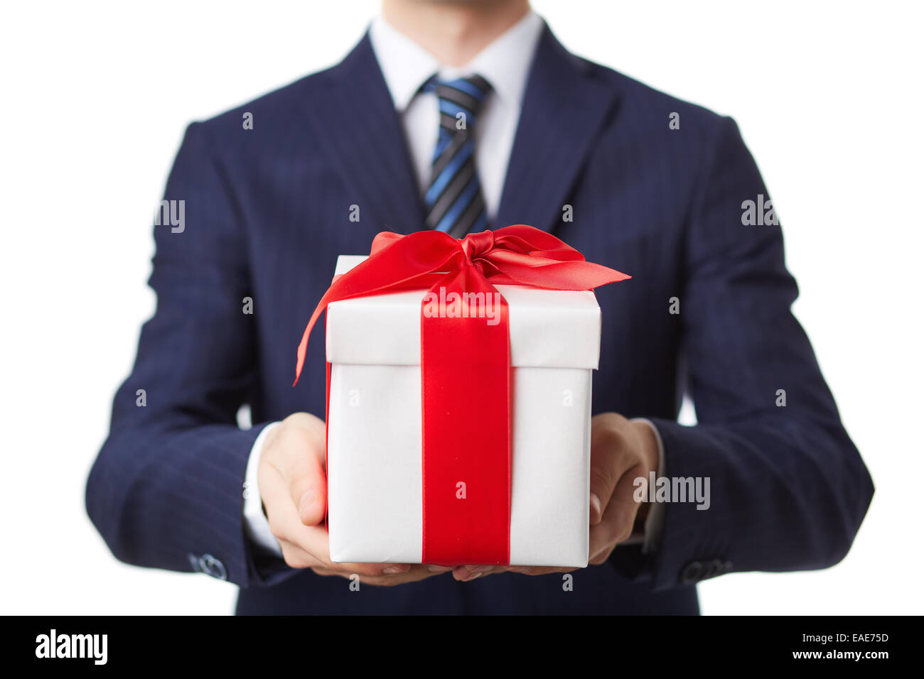 Businessman in suit holding giftbox tied by red ribbon Stock Photo - Alamy