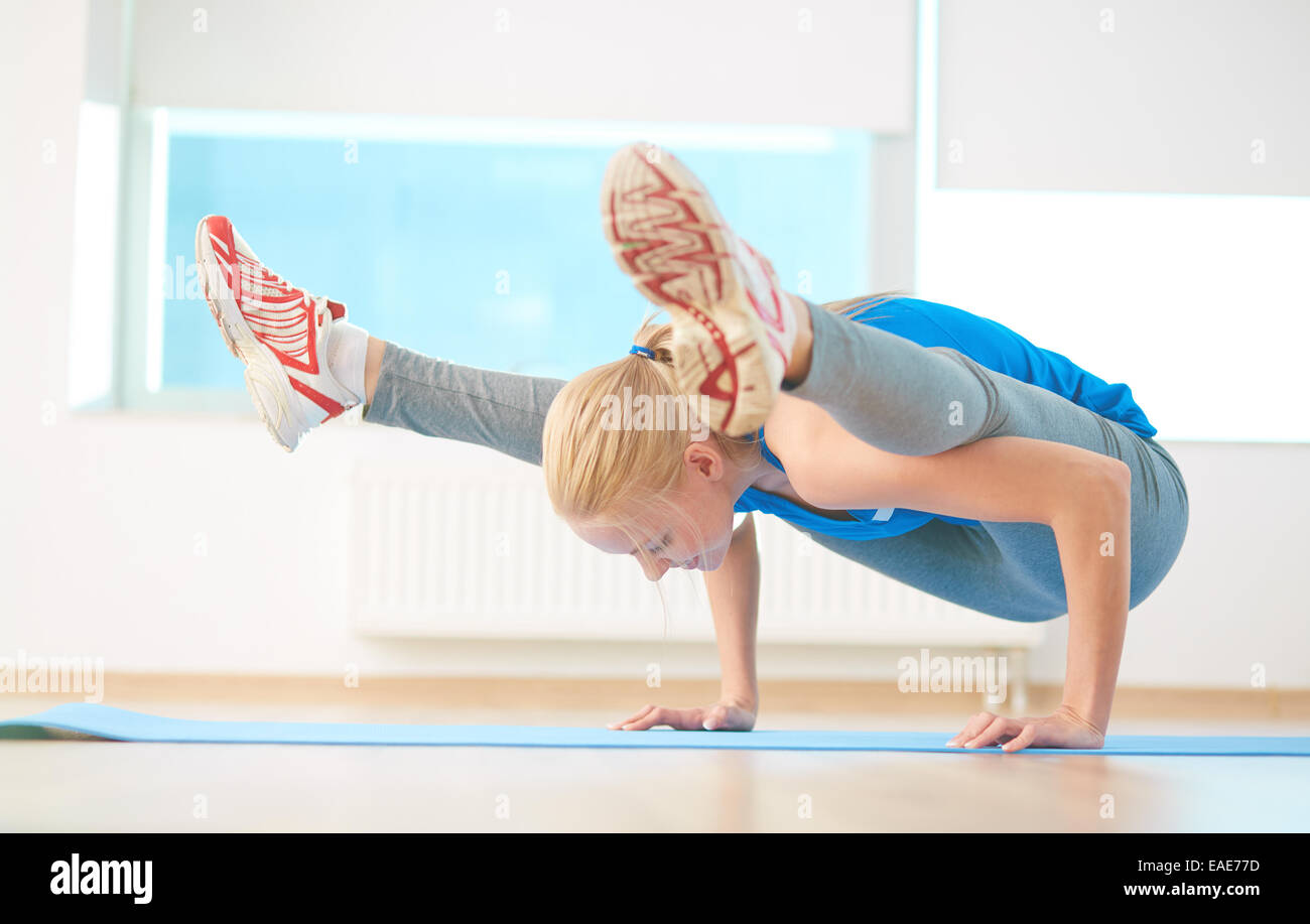 Agile blond girl standing on arms with her legs on forearms Stock Photo ...