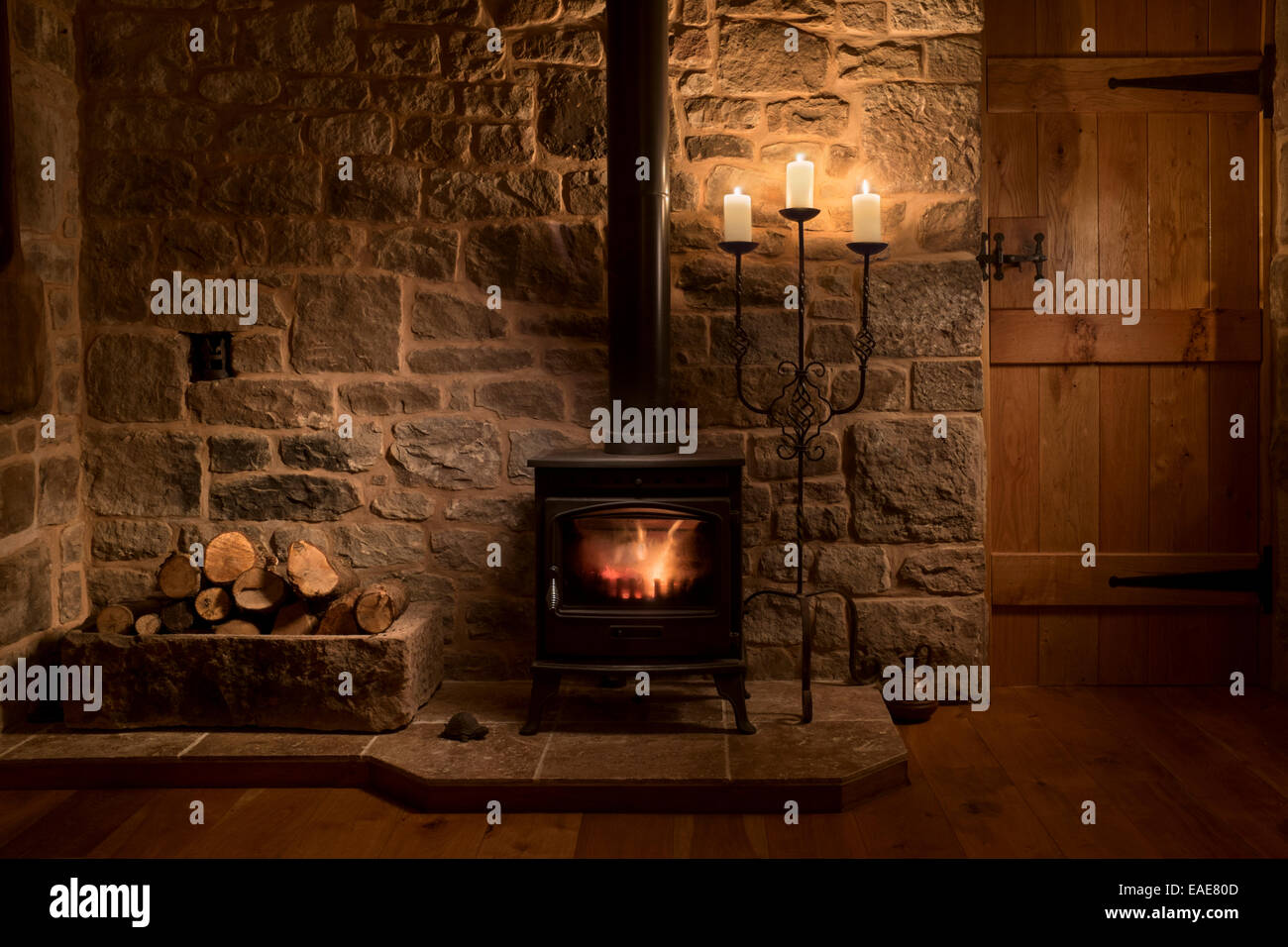 Wood burning stove and logs in a cottage living room Stock Photo - Alamy