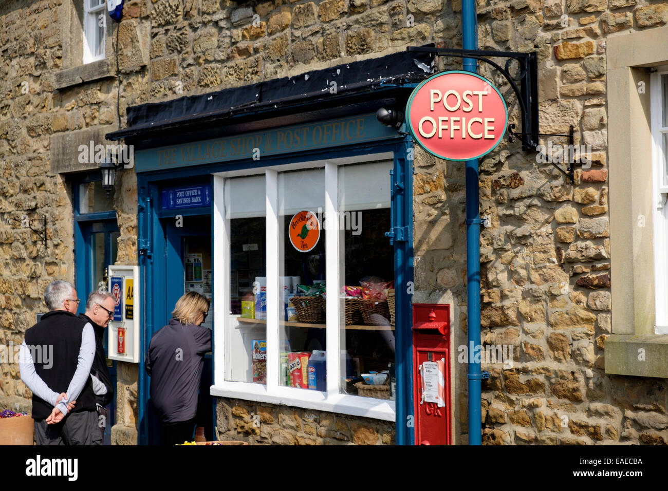 People walking into Post Office Peak District village of Pilsley near ...