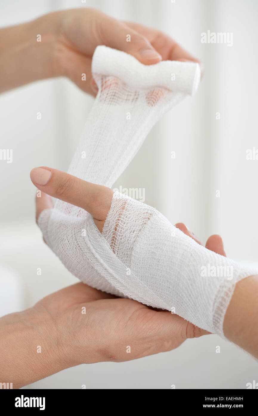 A woman puts on a dressing to the left hand of a patient Stock Photo ...