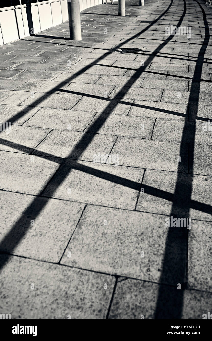 Parallel shadows trace they're way across the sidewalk Stock Photo - Alamy