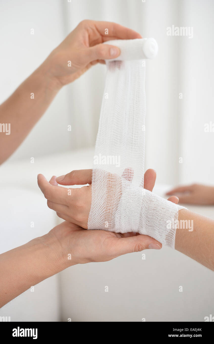 A woman puts on a dressing to the left hand of a patient Stock Photo ...