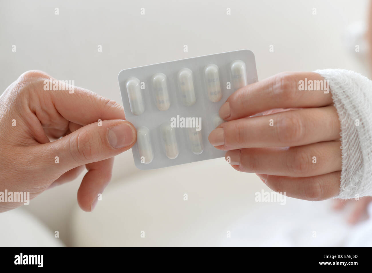 A woman is giving an injured patient tablets Stock Photo - Alamy