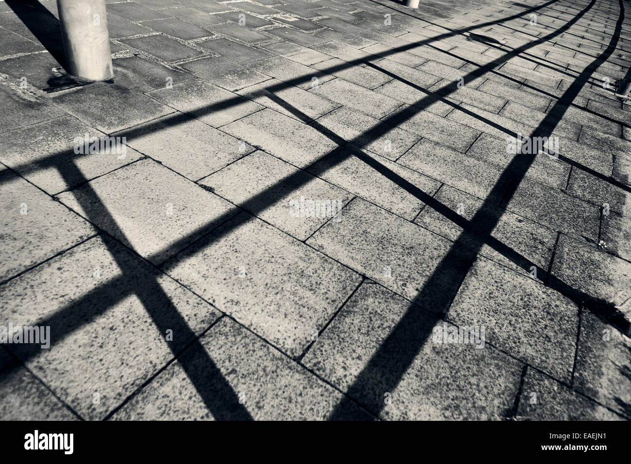 Parallel shadows trace they're way across the sidewalk Stock Photo - Alamy