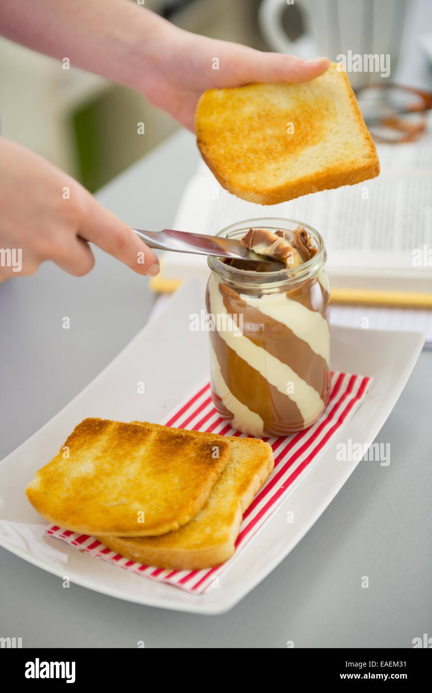 Closeup on young woman spread toast with chocolate cream Stock Photo ...