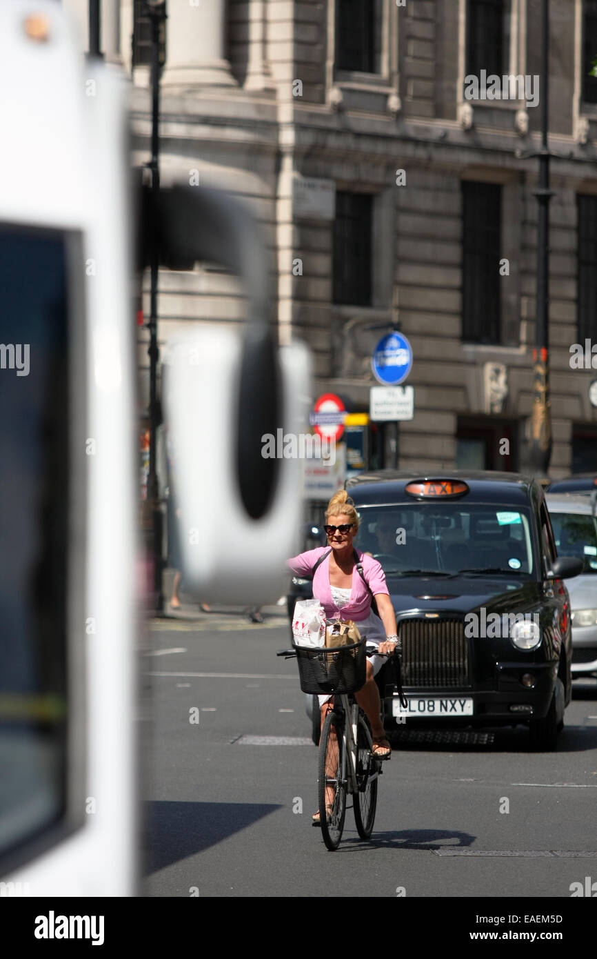 A female cyclist indicating a right turn in London traffic Stock Photo ...